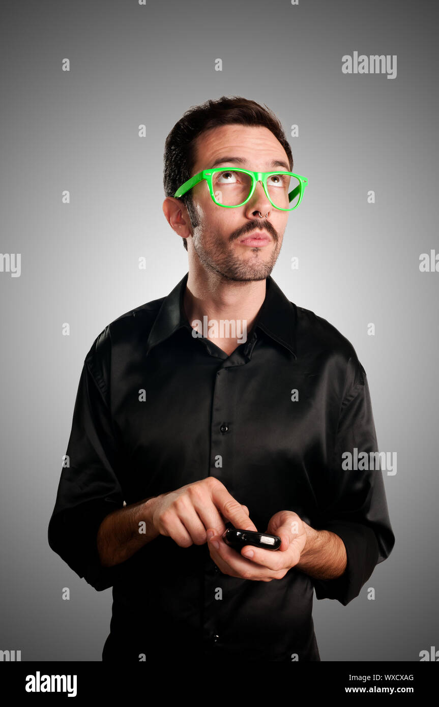 thinking man holding phone on gray background Stock Photo - Alamy