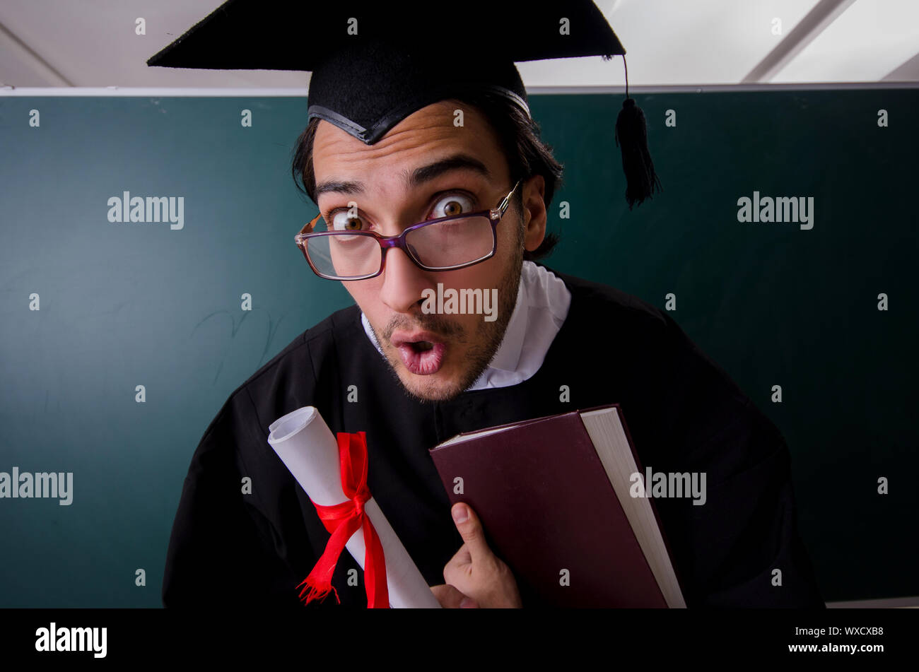 Graduate student in front of green board Stock Photo - Alamy