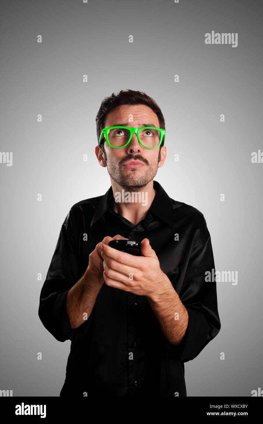 thinking man holding phone on gray background Stock Photo - Alamy