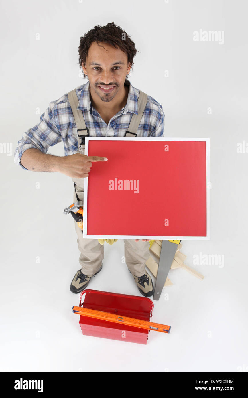 Carpenter pointing at red panel Stock Photo - Alamy