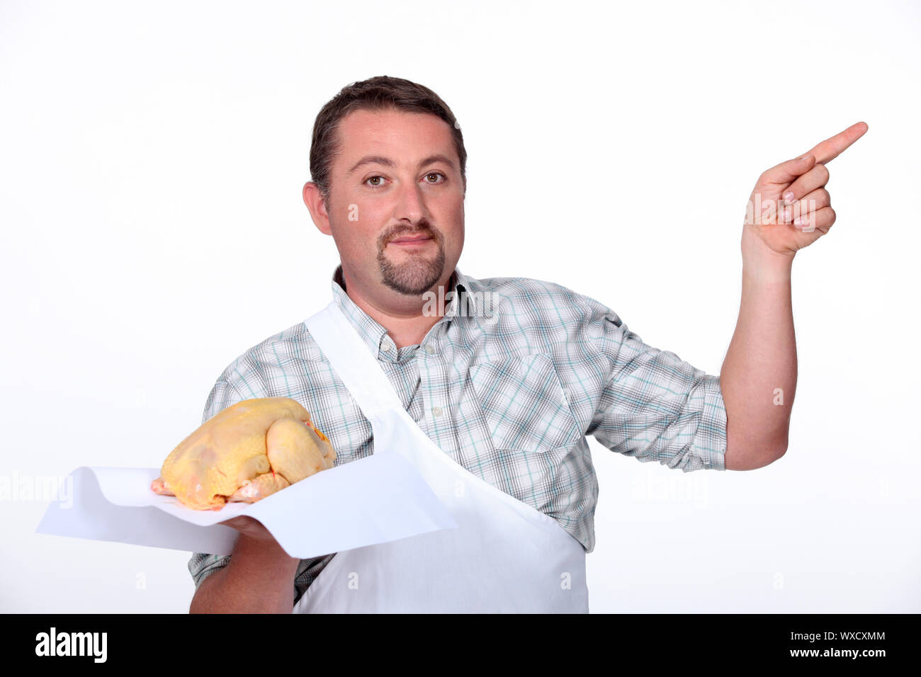 Butcher pointing with a chicken Stock Photo - Alamy