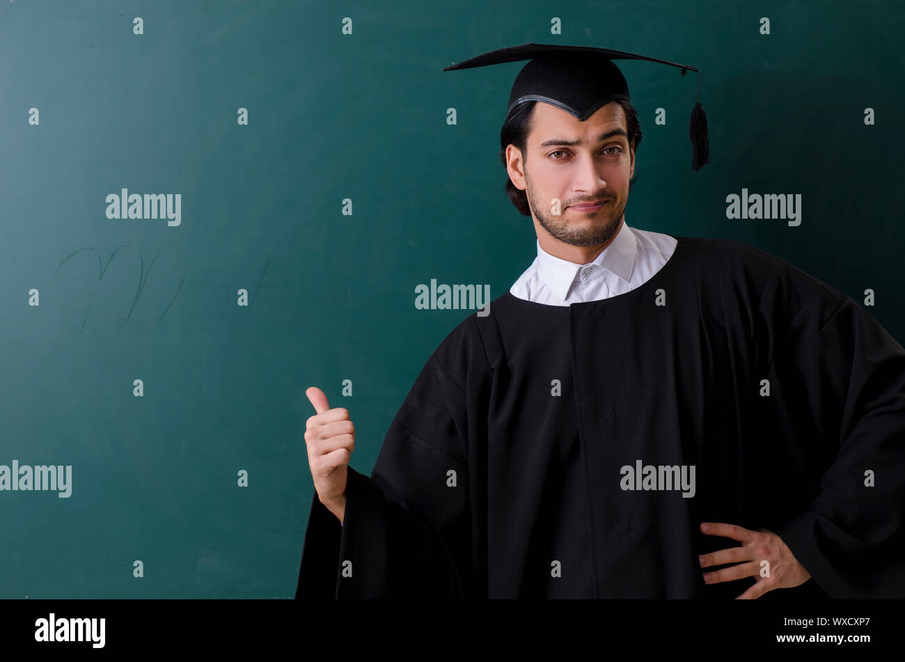 Graduate student in front of green board Stock Photo - Alamy