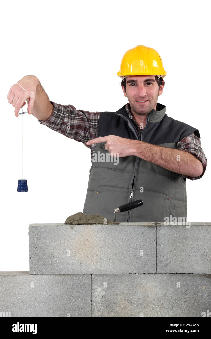 Bricklayer checking that wall is level Stock Photo - Alamy