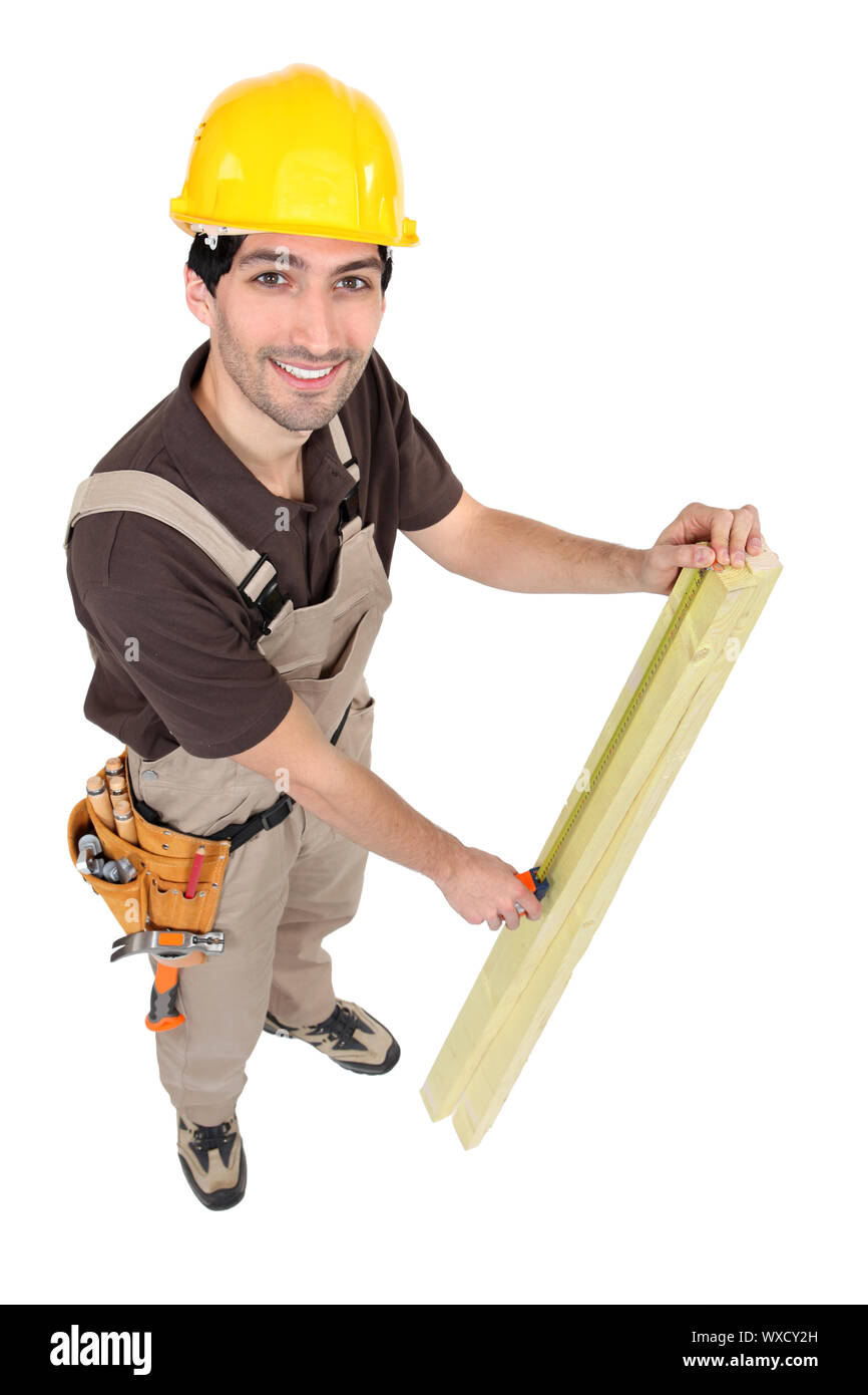 Carpenter measuring plank of wood Stock Photo - Alamy
