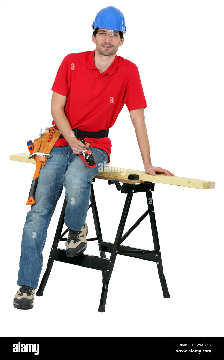 Carpenter sitting on a workbench Stock Photo - Alamy