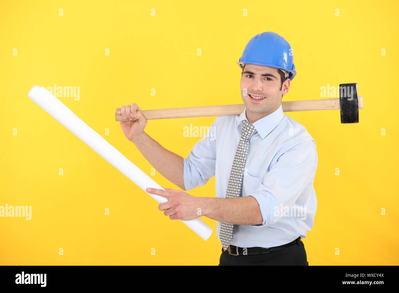 Holding a blueprint and mallet Stock Photo - Alamy
