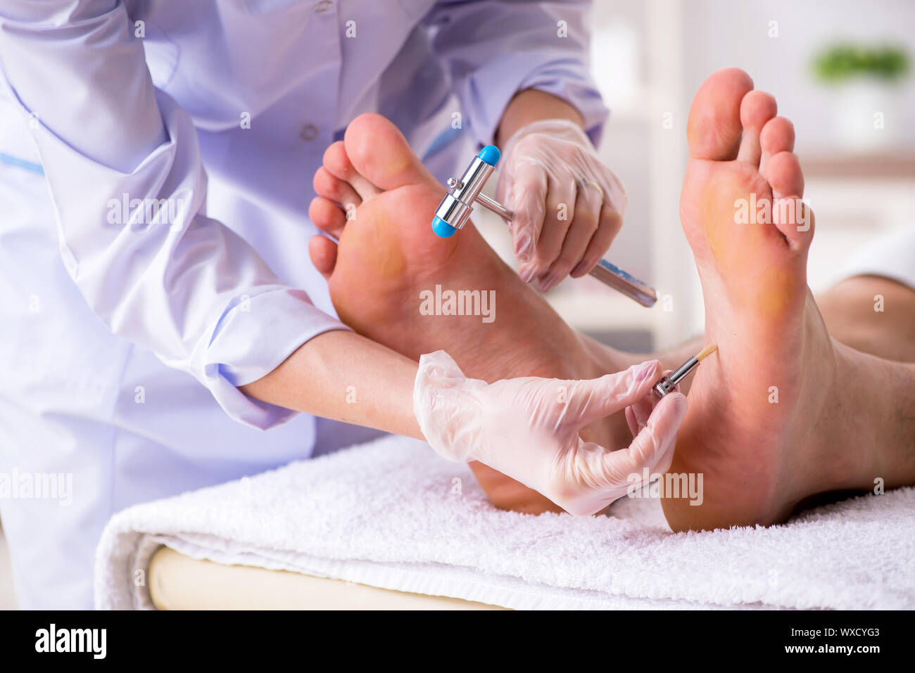 Podiatrist treating feet during procedure Stock Photo - Alamy