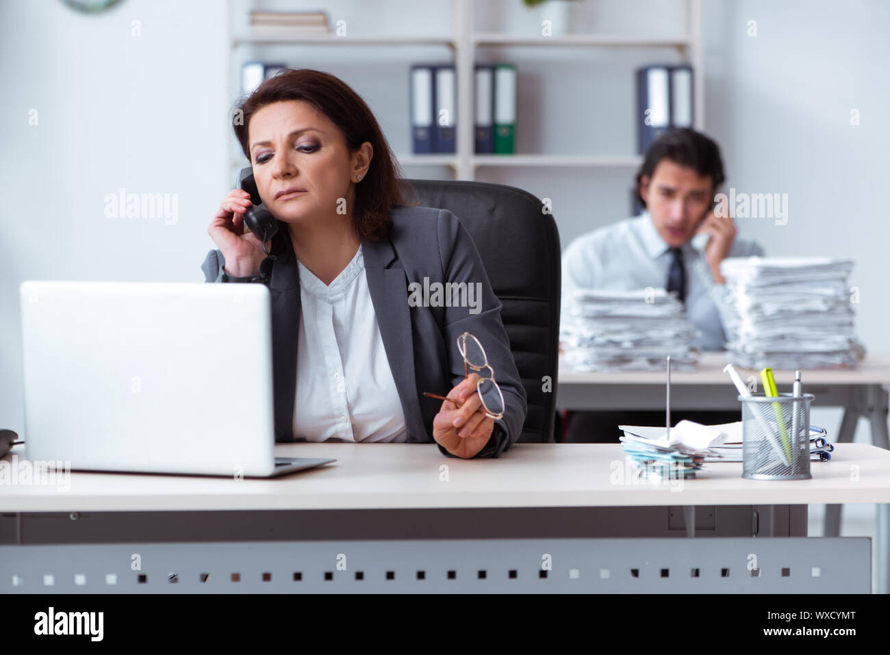 Old female boss and young male employee in the office Stock Photo - Alamy