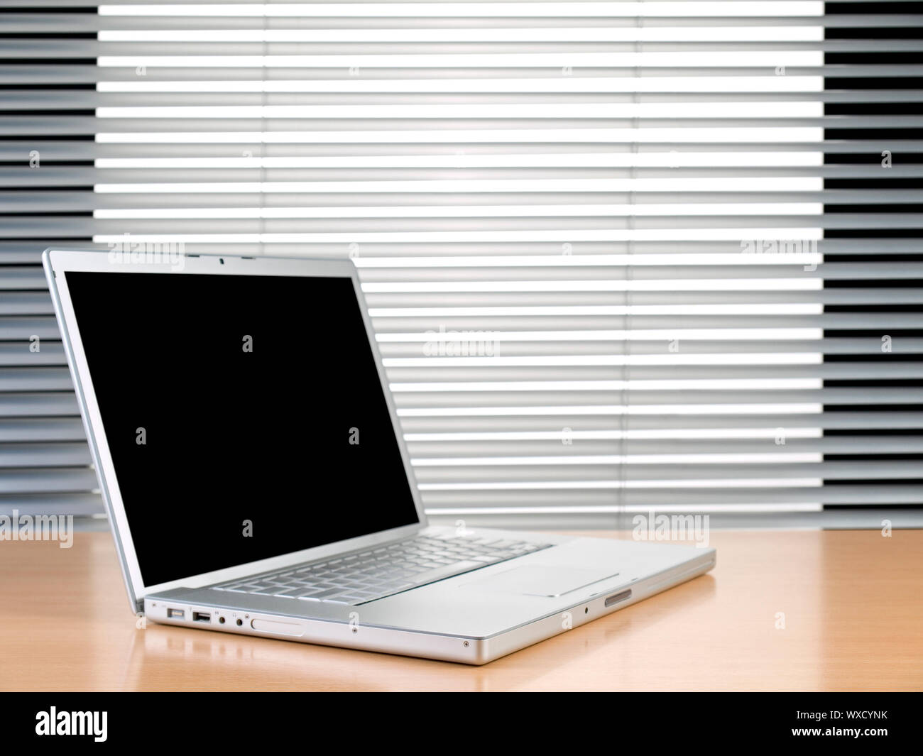 A laptop on a table at a modern office Stock Photo - Alamy