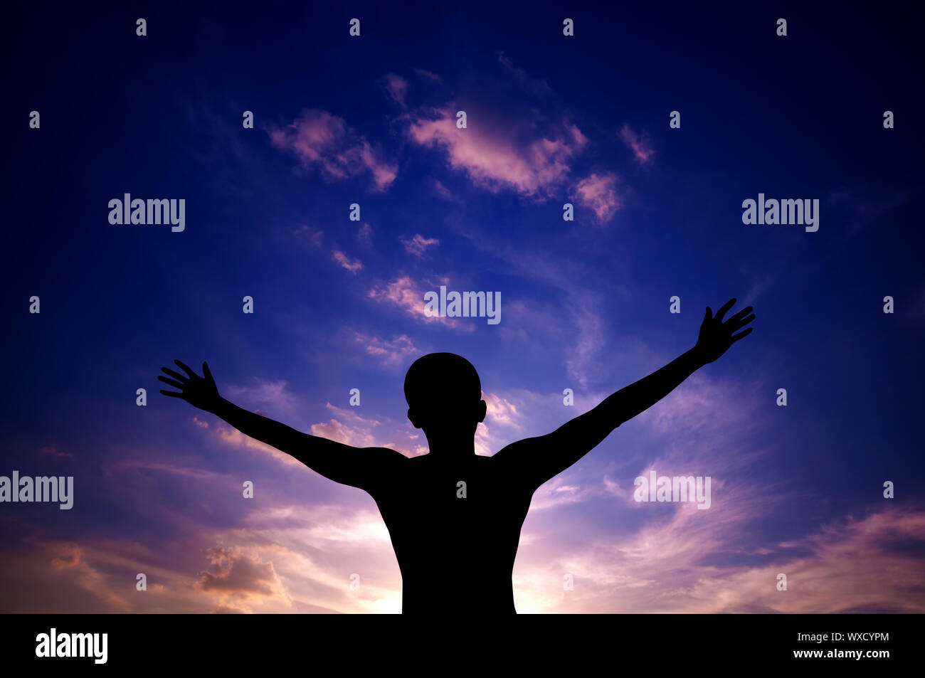 Silhouette or backlit of Asian man open arms raised towards sky on ...