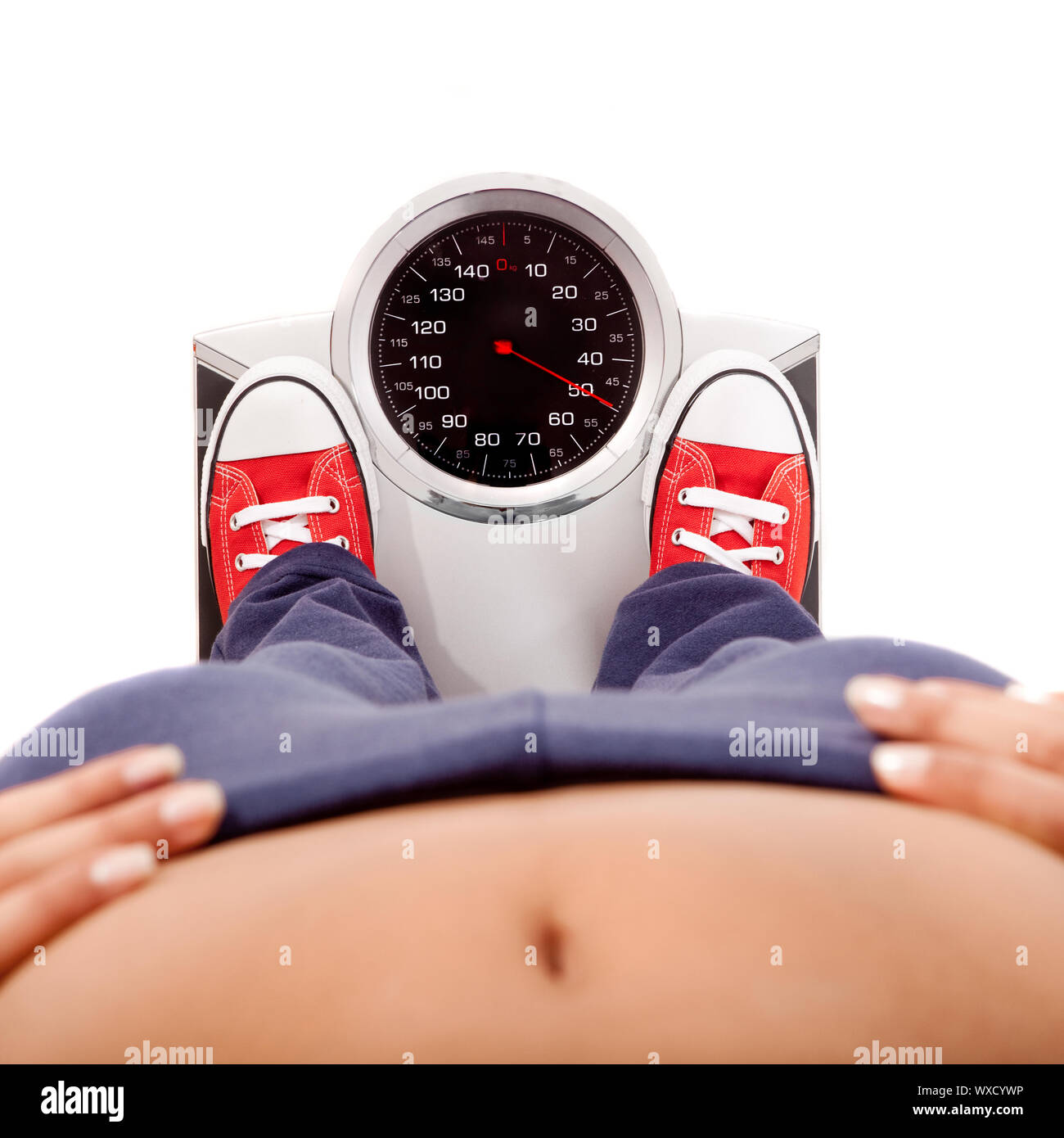 Athletic young girl measuring her weight on a balance Stock Photo - Alamy