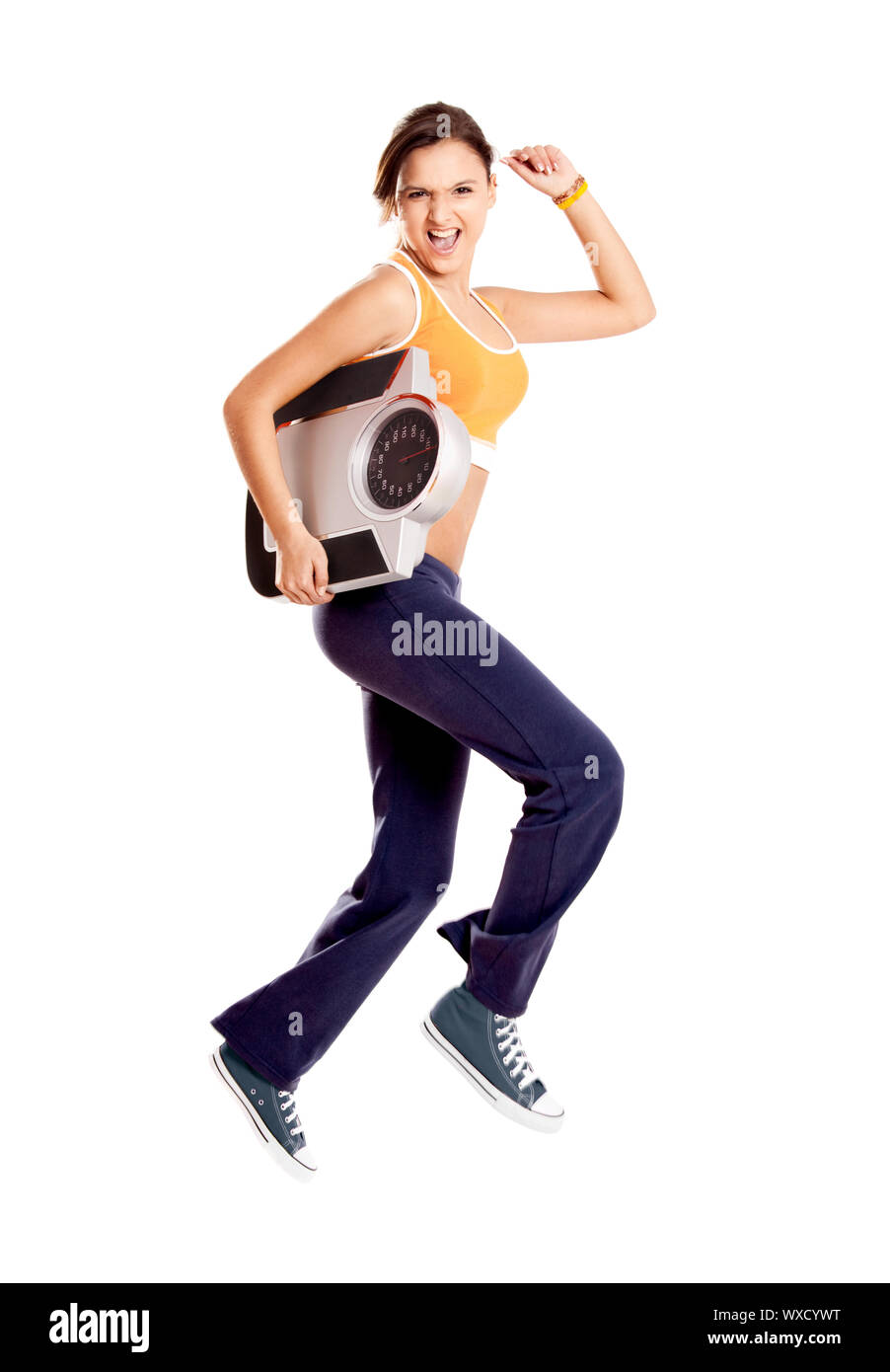 Beautiful athletic girl holding a scale and jumping, isolated on white ...