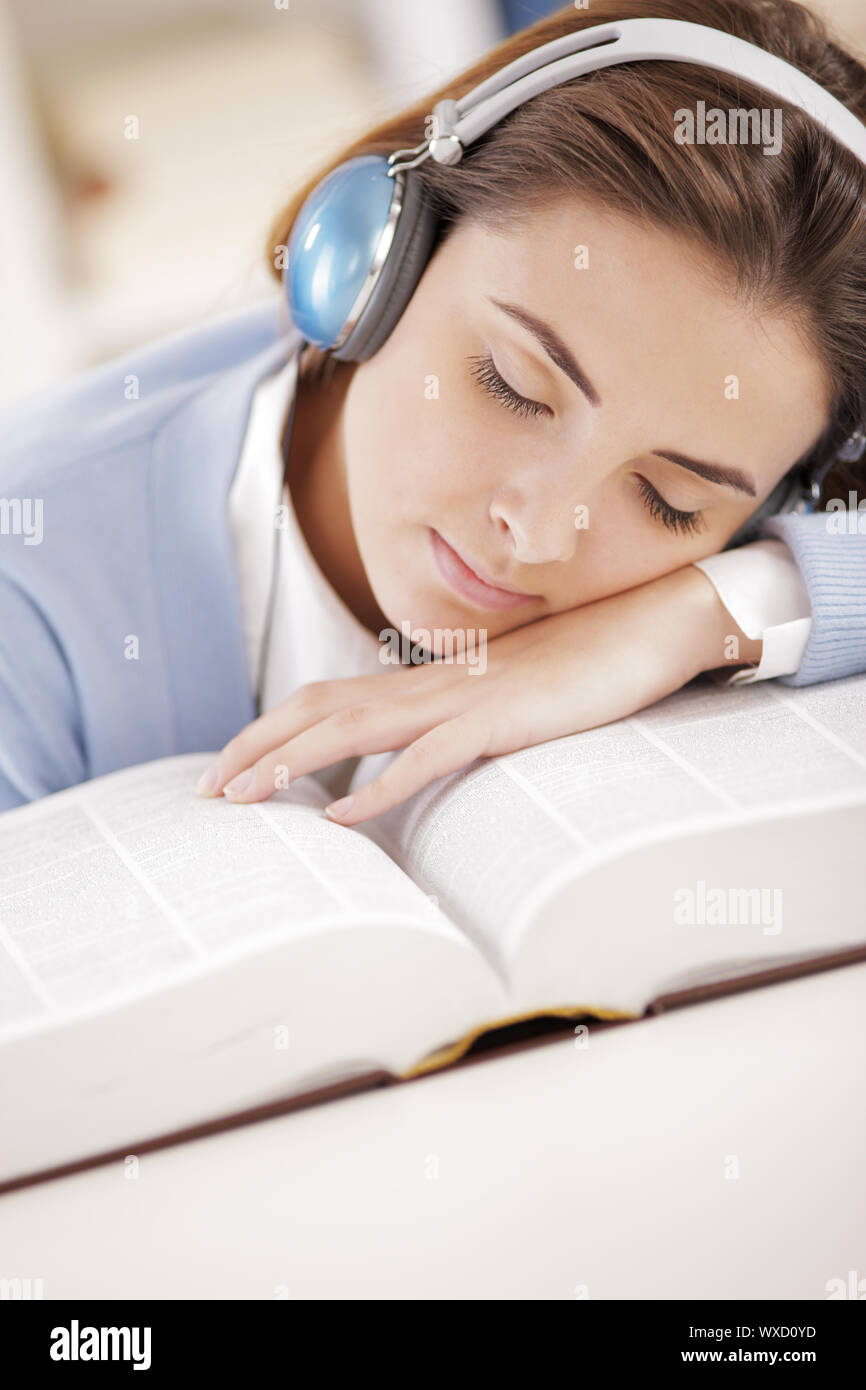 female student sleeping listening music on open book Stock Photo - Alamy