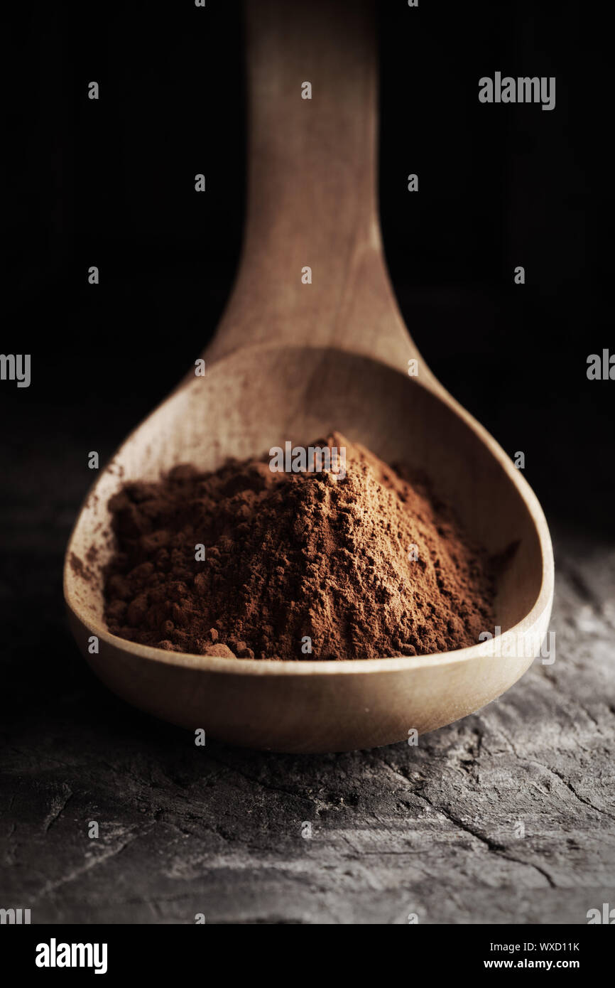 Wooden spoon full of cocoa powder Stock Photo - Alamy