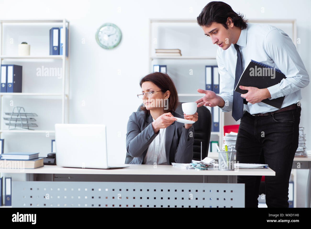 Old female boss and young male employee in the office Stock Photo - Alamy