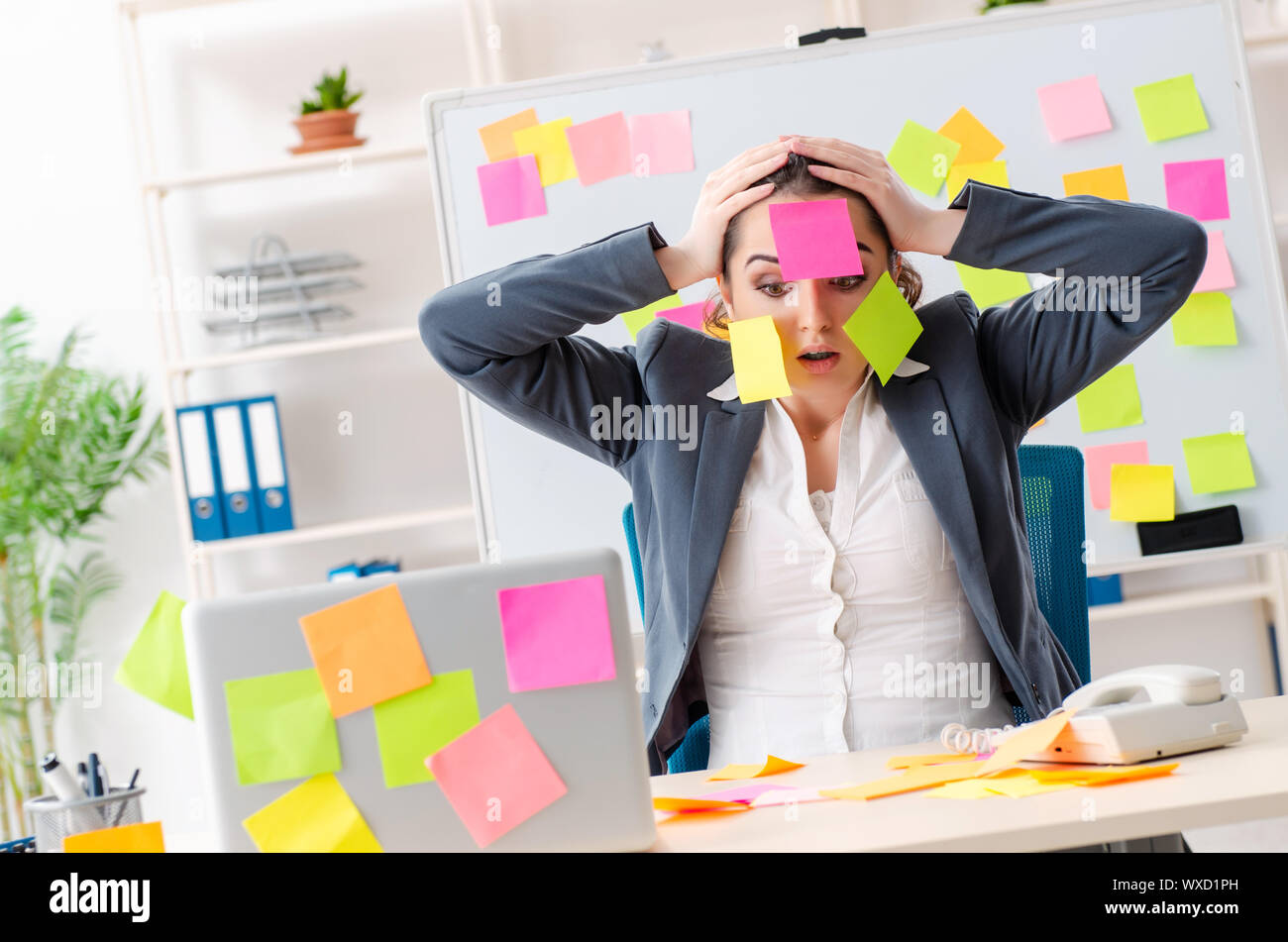 Young female employee in conflicting priorities concept Stock Photo - Alamy