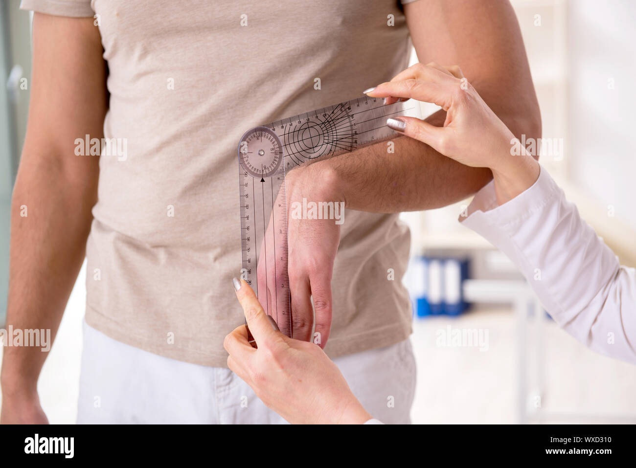 Female doctor checking patient's joint flexibility with goniometer ...