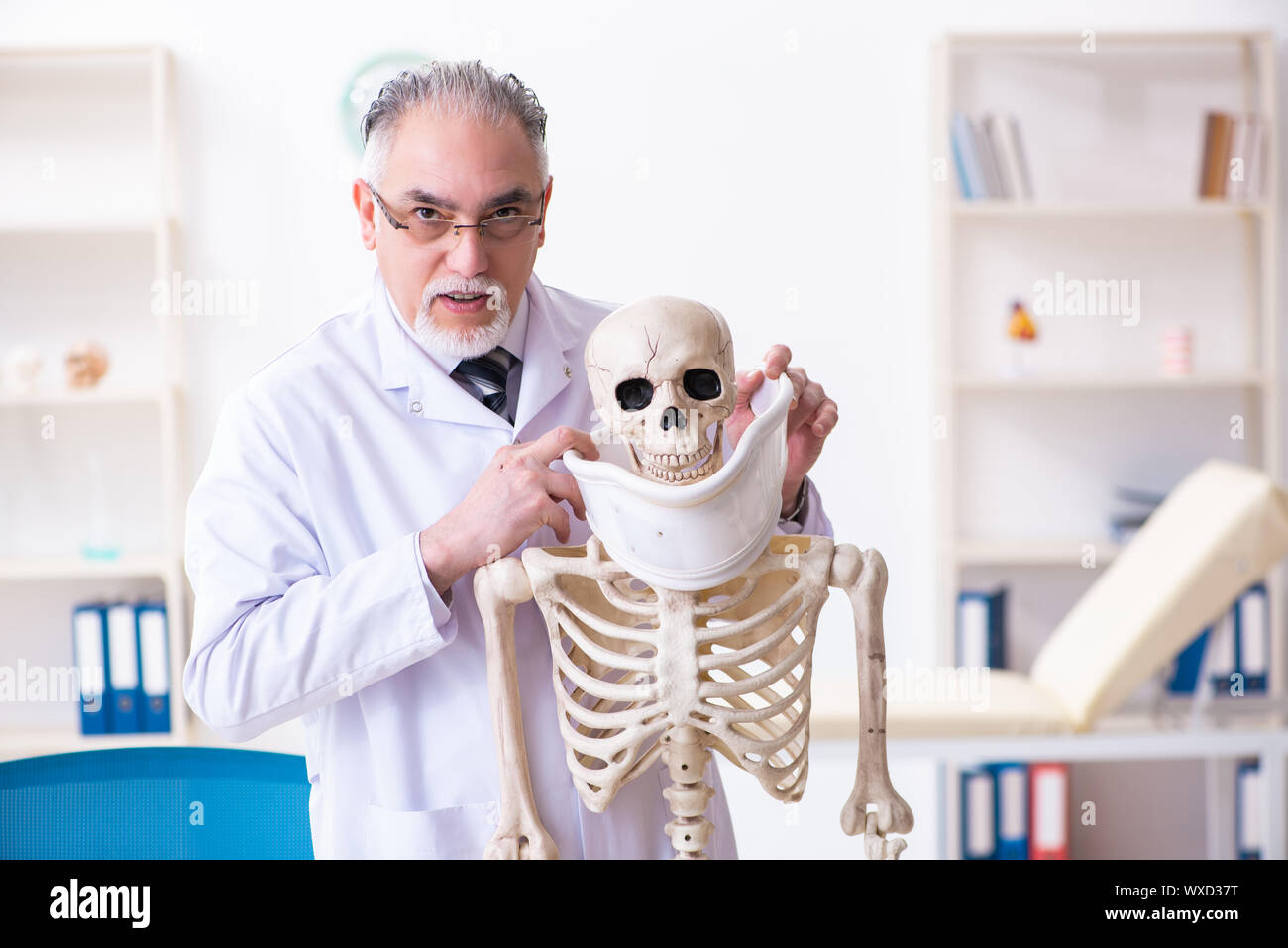 Aged male doctor with skeleton Stock Photo - Alamy