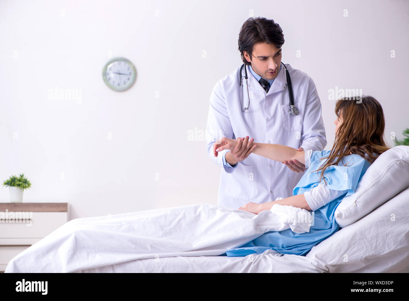 Male doctor visiting female patient in ward Stock Photo - Alamy