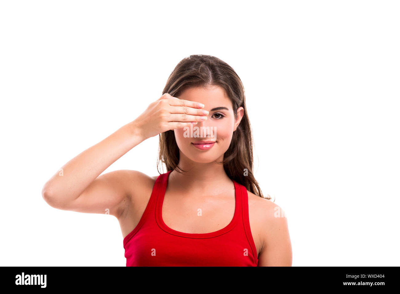 Beautiful young woman covering one eye with her hand, isolated over a ...