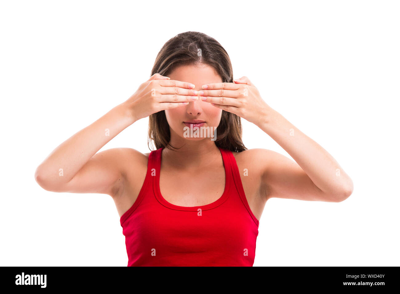 Beautiful young woman covering both eyes with her hands, isolated over ...