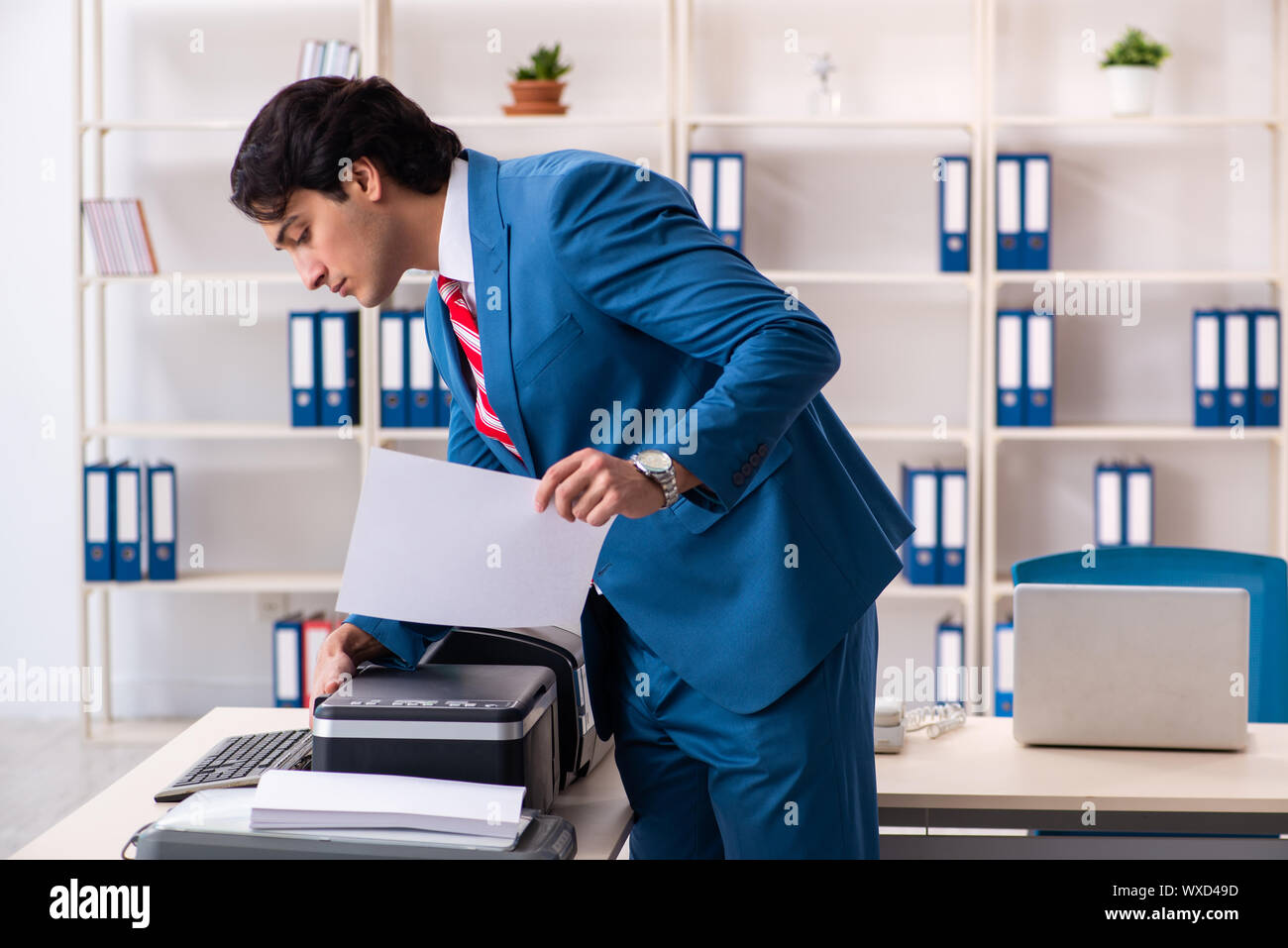 Young employee making copies at copying machine Stock Photo - Alamy