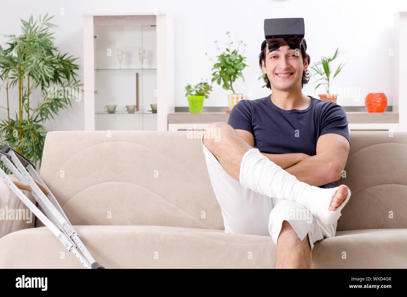 Leg injured young man suffering at home Stock Photo - Alamy