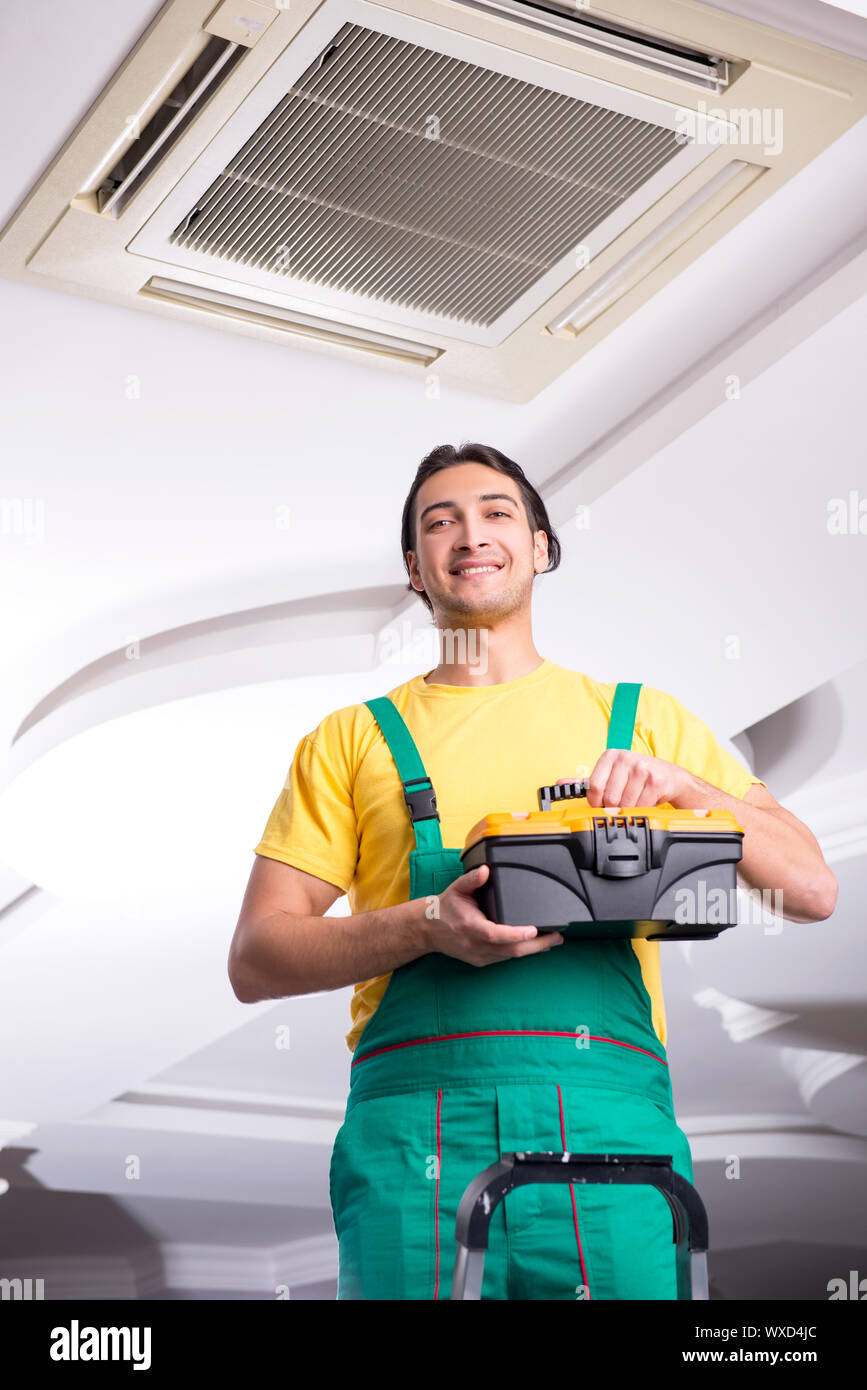 Young repairman repairing ceiling air conditioning unit Stock Photo - Alamy