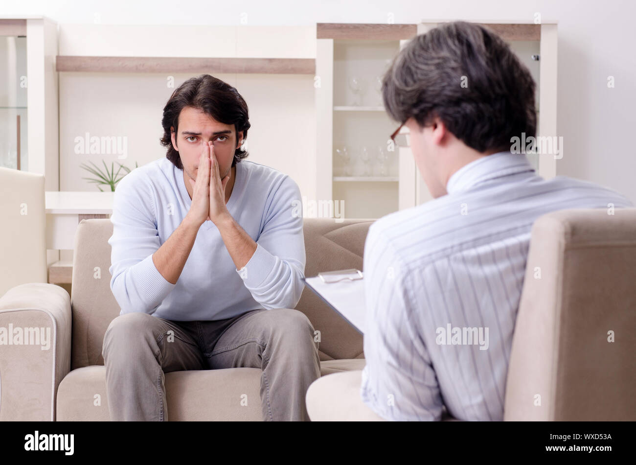 Young male patient discussing with psychologist personal problem Stock ...