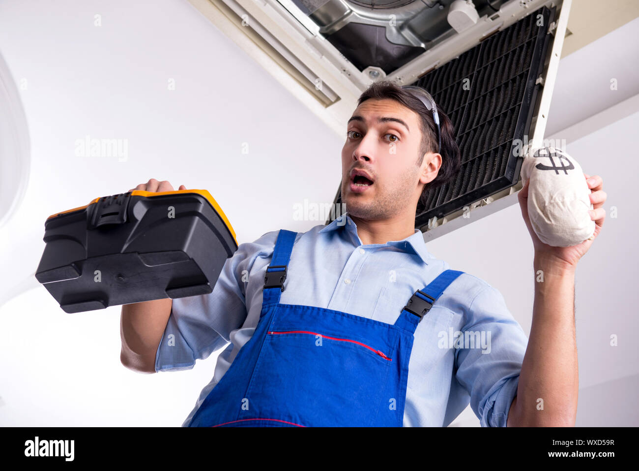Young repairman repairing ceiling air conditioning unit Stock Photo - Alamy