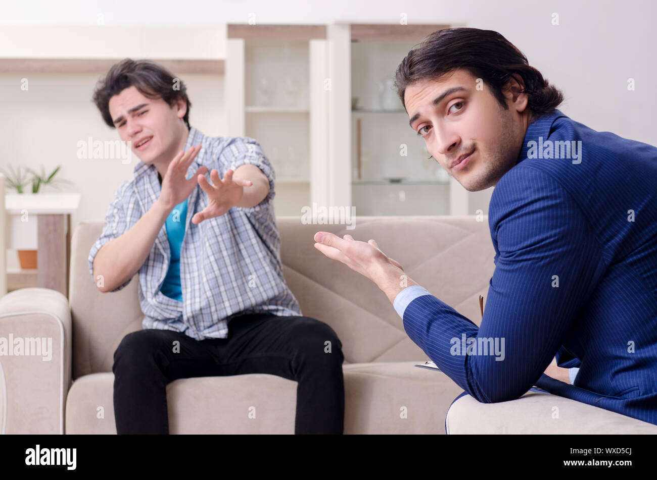 Young male patient discussing with psychologist personal problem Stock ...