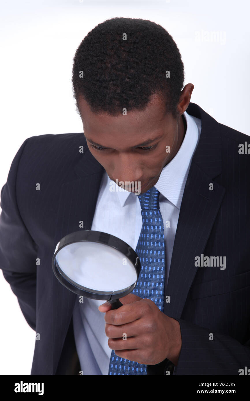 Curious man inspecting an object with a magnifying glass Stock Photo ...