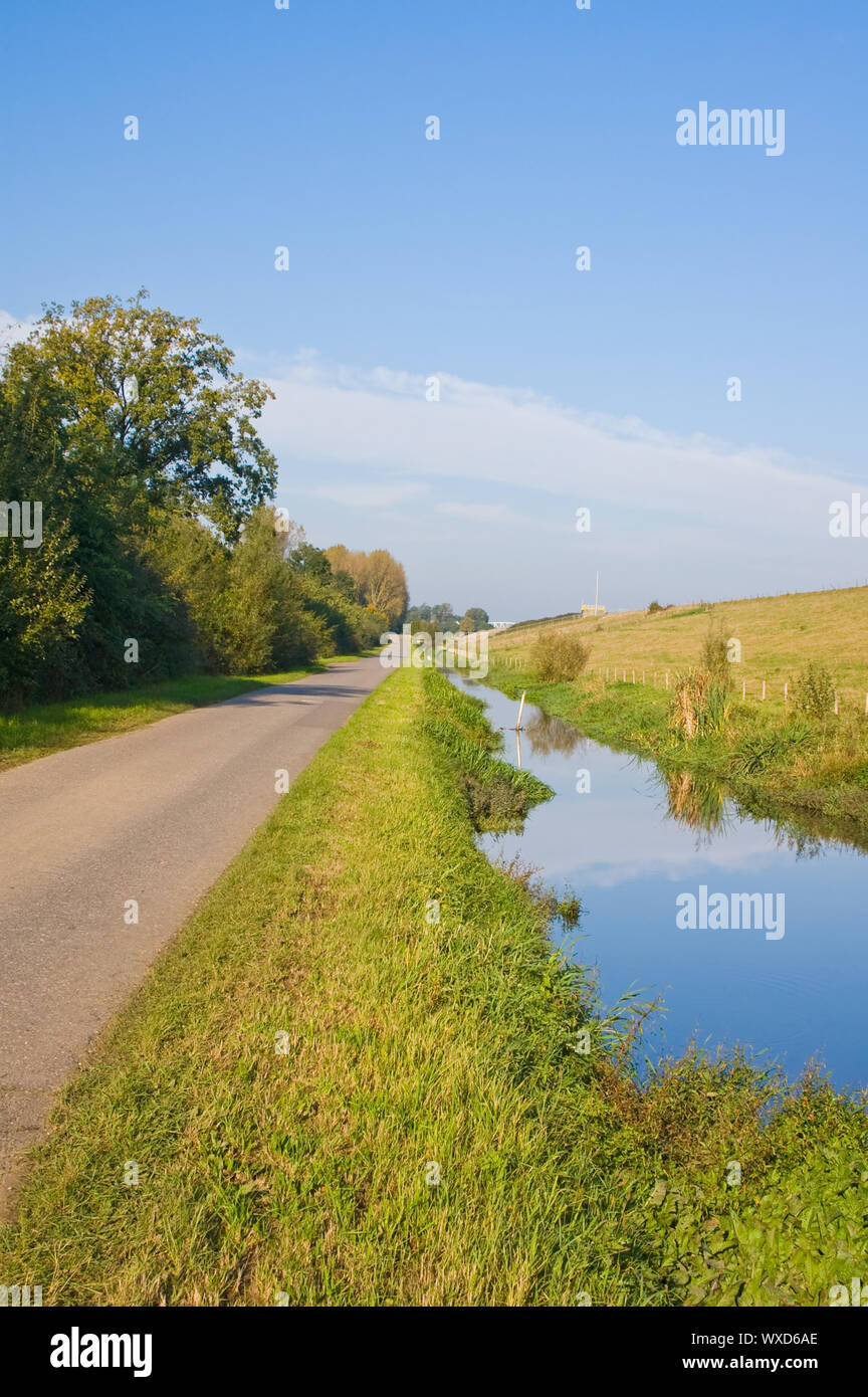 green dike with a ditch and reflection in the water Stock Photo - Alamy
