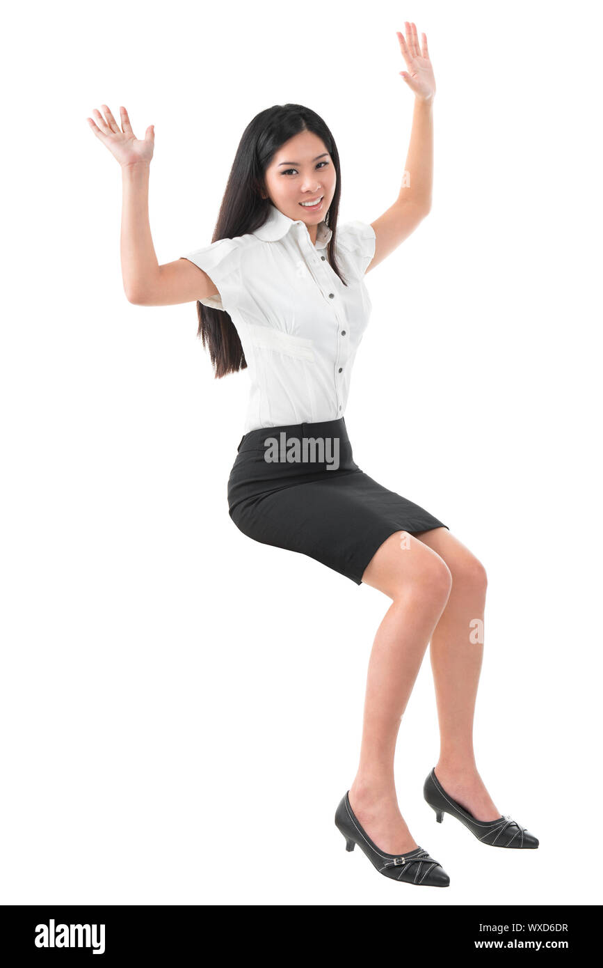 Full body arms raised young Asian woman sitting on invisible chair over ...