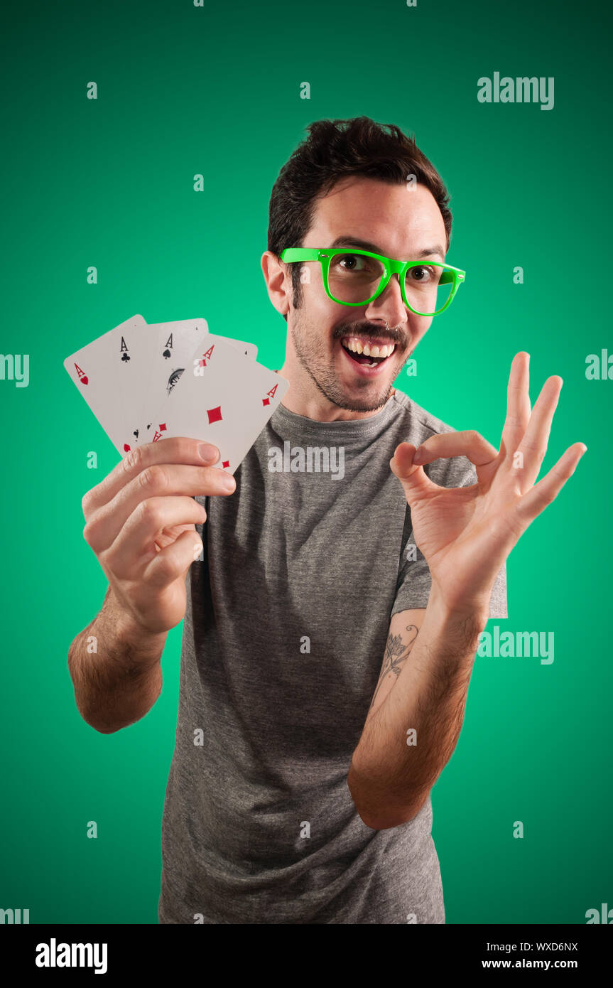 winner guy holding poker cards on green background Stock Photo - Alamy