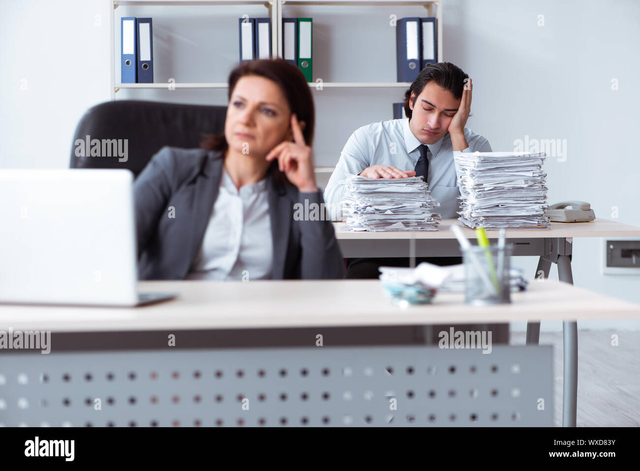 Old female boss and young male employee in the office Stock Photo - Alamy