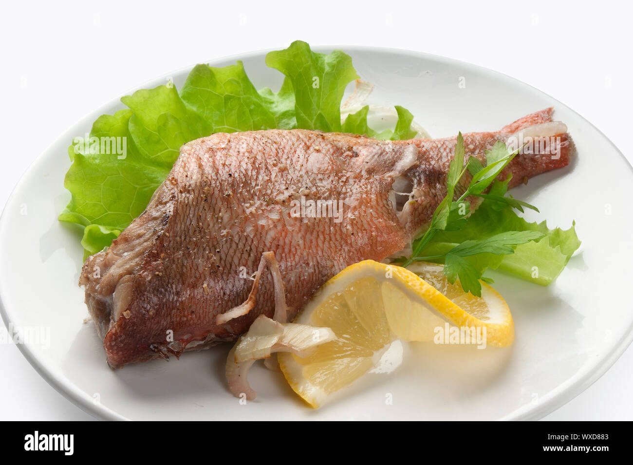 Baked rosefish with lettuce and lemon on the plate Stock Photo - Alamy