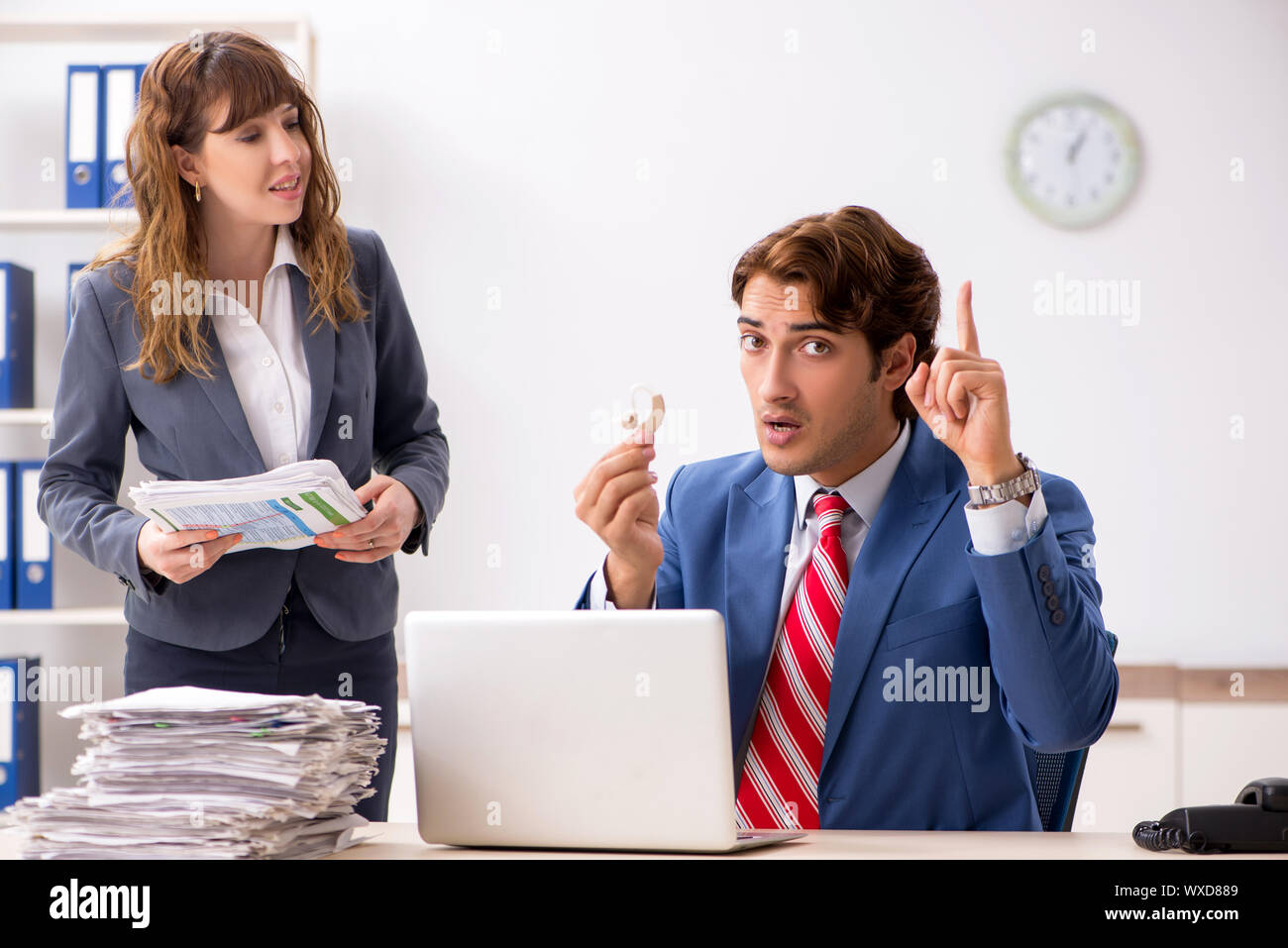 Deaf employee using hearing aid talking to boss Stock Photo - Alamy