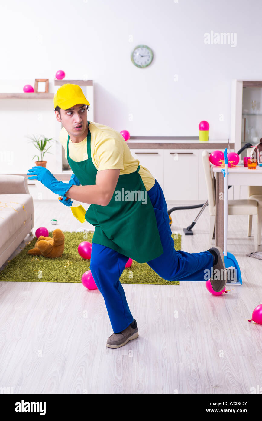 Young male contractor doing housework after party Stock Photo - Alamy