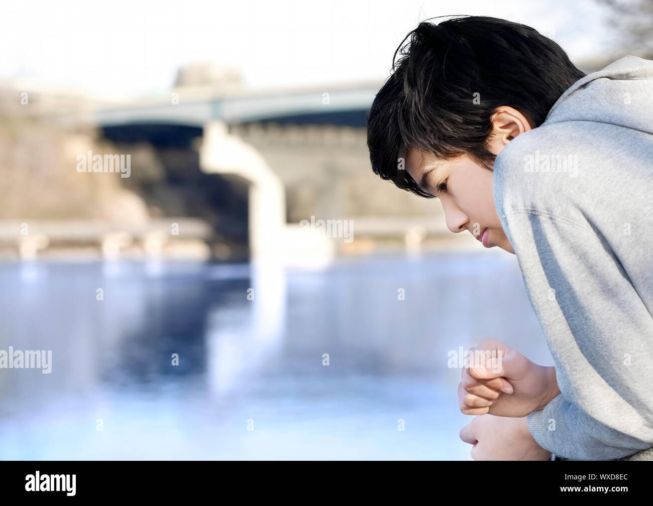 Teen boy sadly looking out over river, deep in thought Stock Photo - Alamy