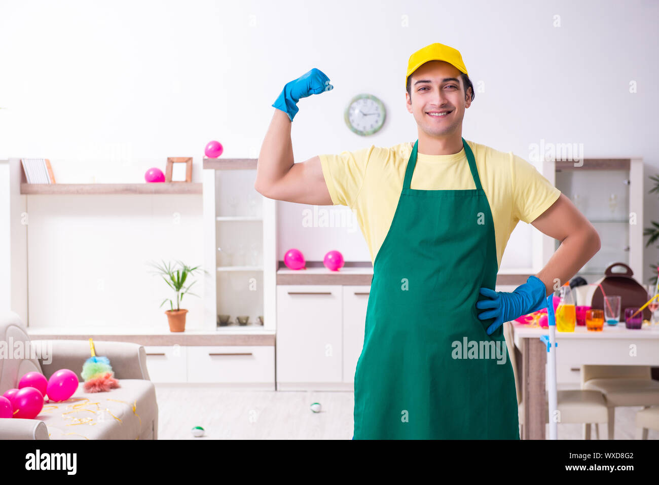 Young male contractor doing housework after party Stock Photo - Alamy