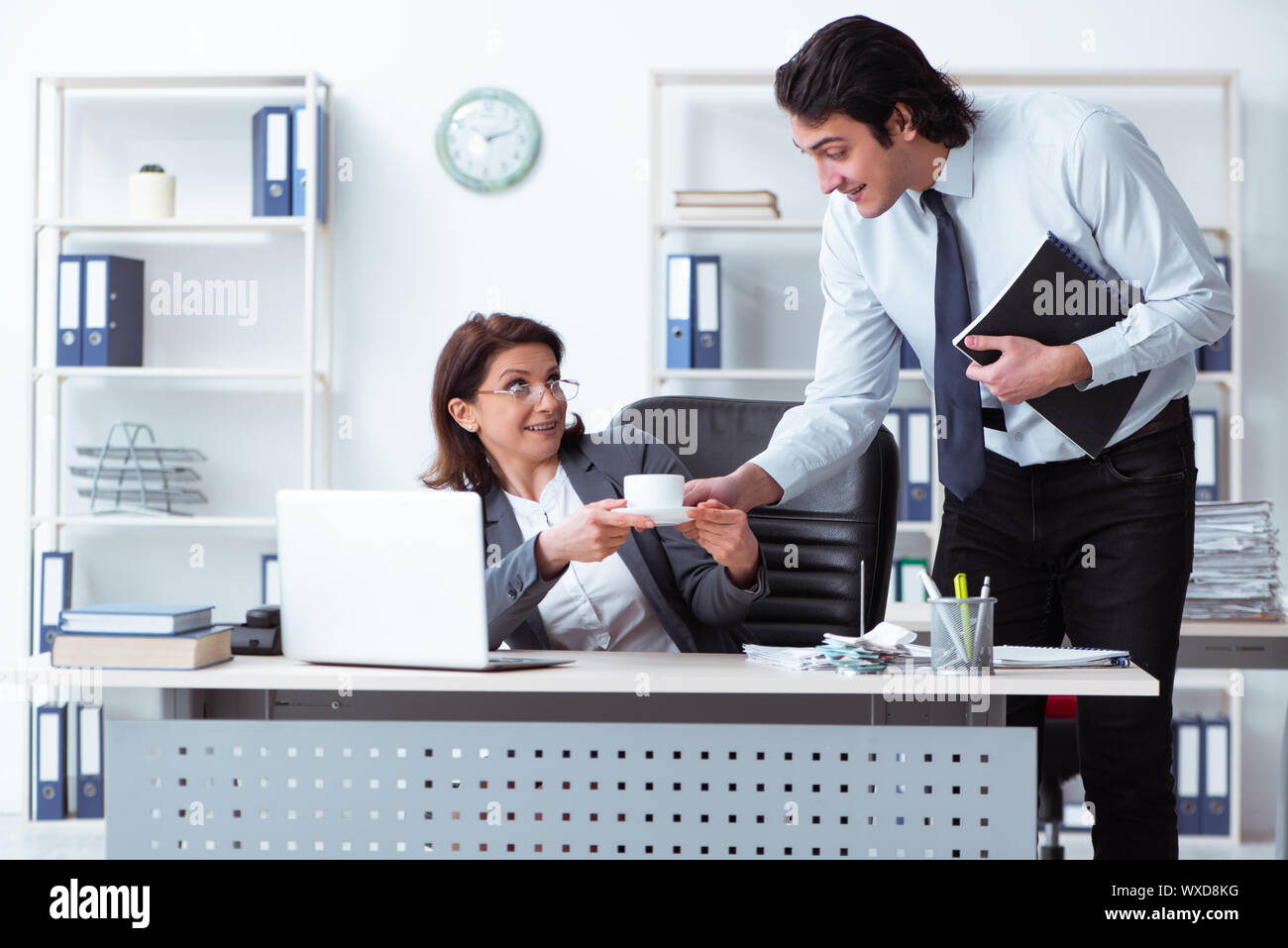 Old female boss and young male employee in the office Stock Photo - Alamy
