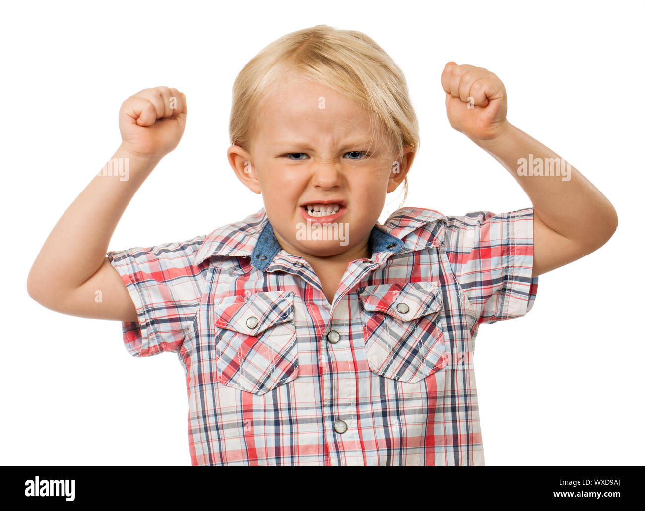 A frustrated and angry young boy with fists raised in the air and ...