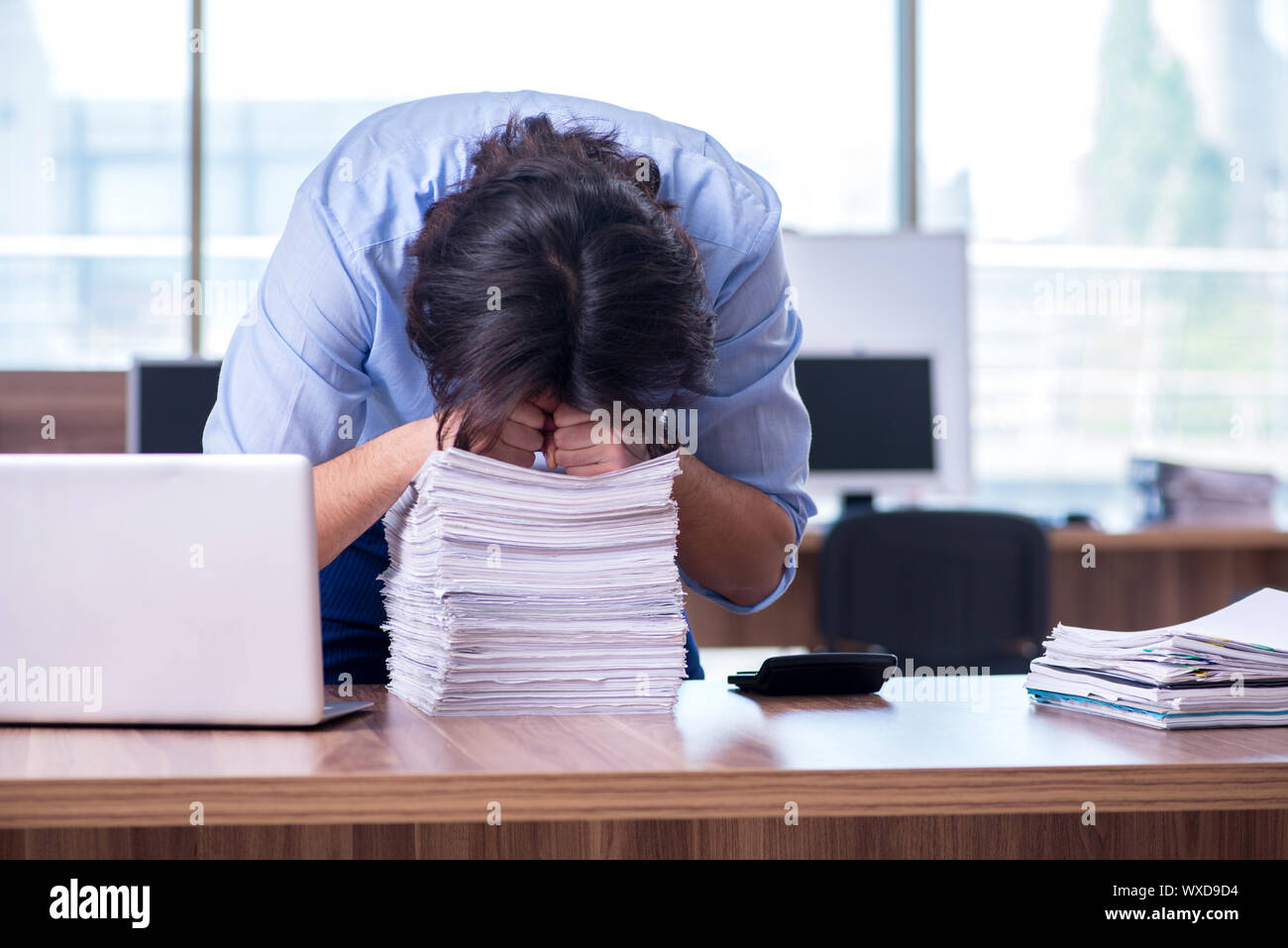 Young employee unhappy with excessive work Stock Photo - Alamy