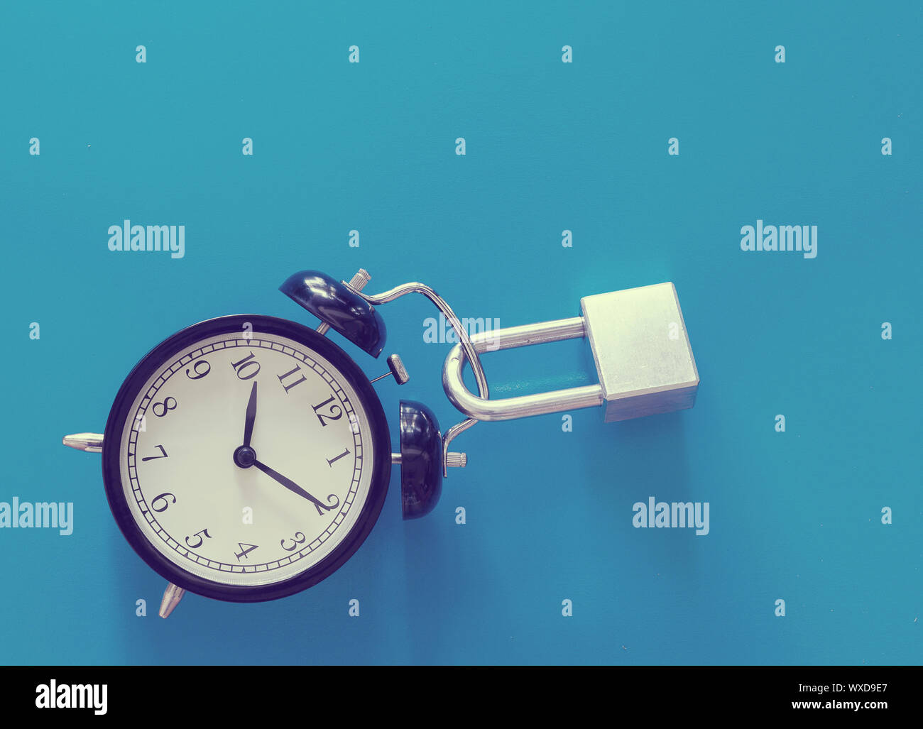 Time management concept, busy hour, alarm clock and lock on blue ...