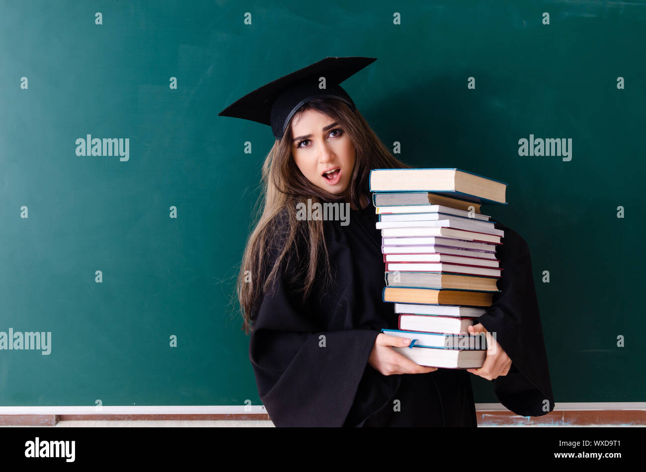 Female graduate student in front of green board Stock Photo - Alamy