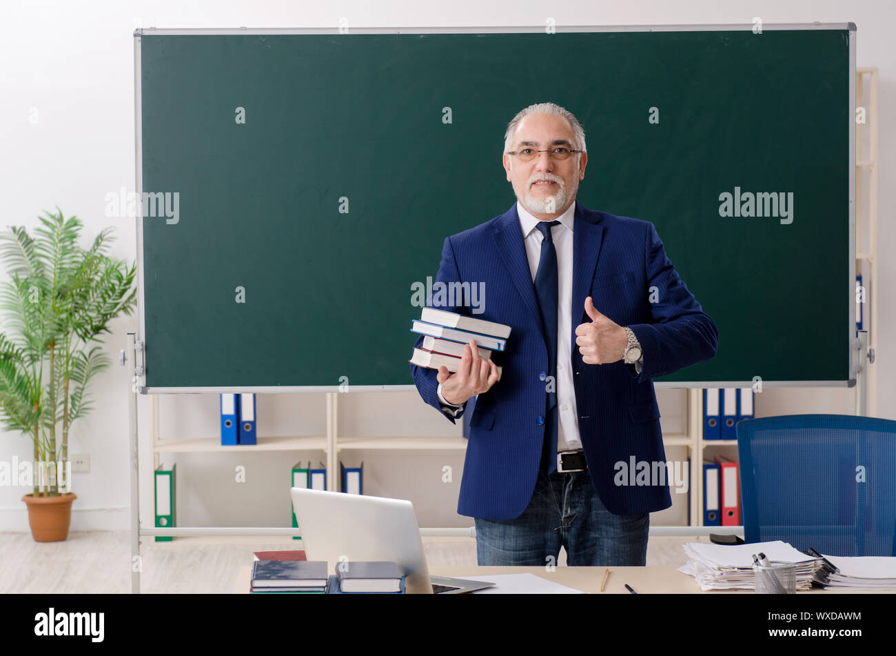 Aged male teacher in front of chalkboard Stock Photo - Alamy