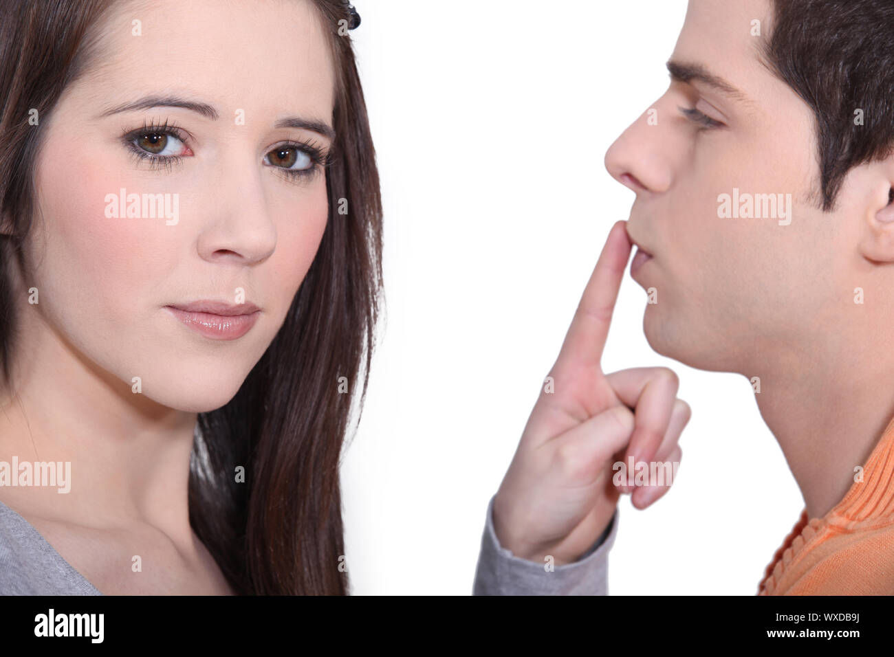 Woman putting her finger on a man's lips Stock Photo - Alamy