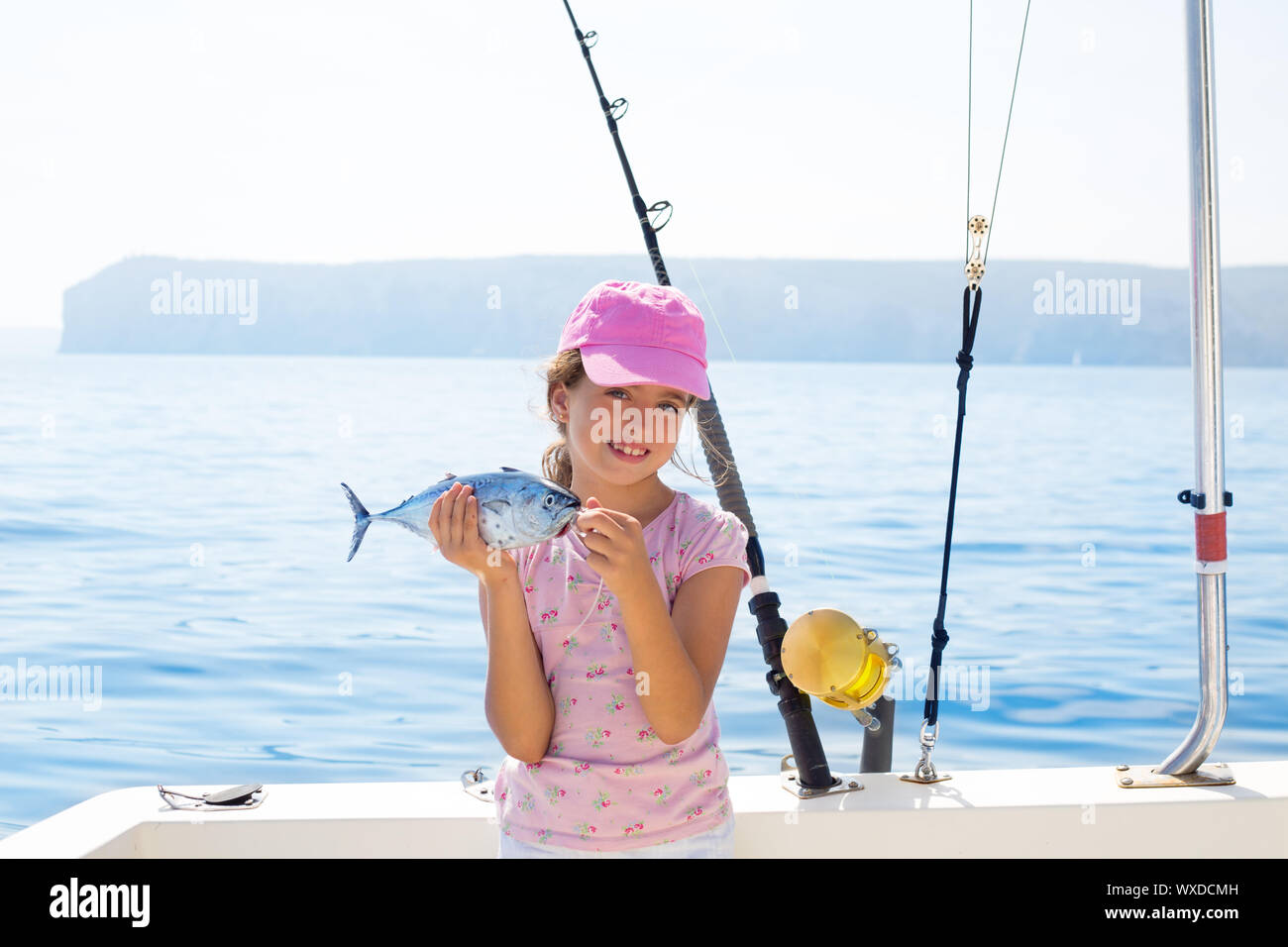 child little girl fishing in boat holding little tunny tuna fish catch ...