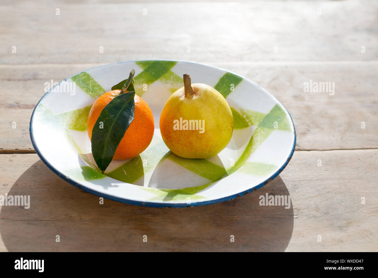 fruits tangerine and pear in vintage porcelain dish plate on retro wood ...